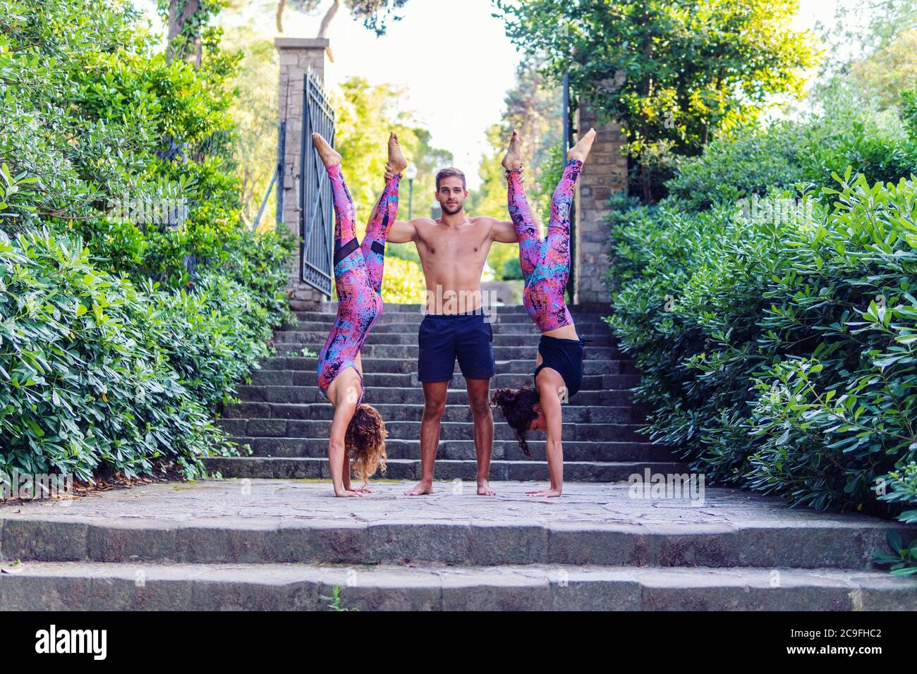 Beautiful man and two women practicing acroyoga Stock Photo - Alamy