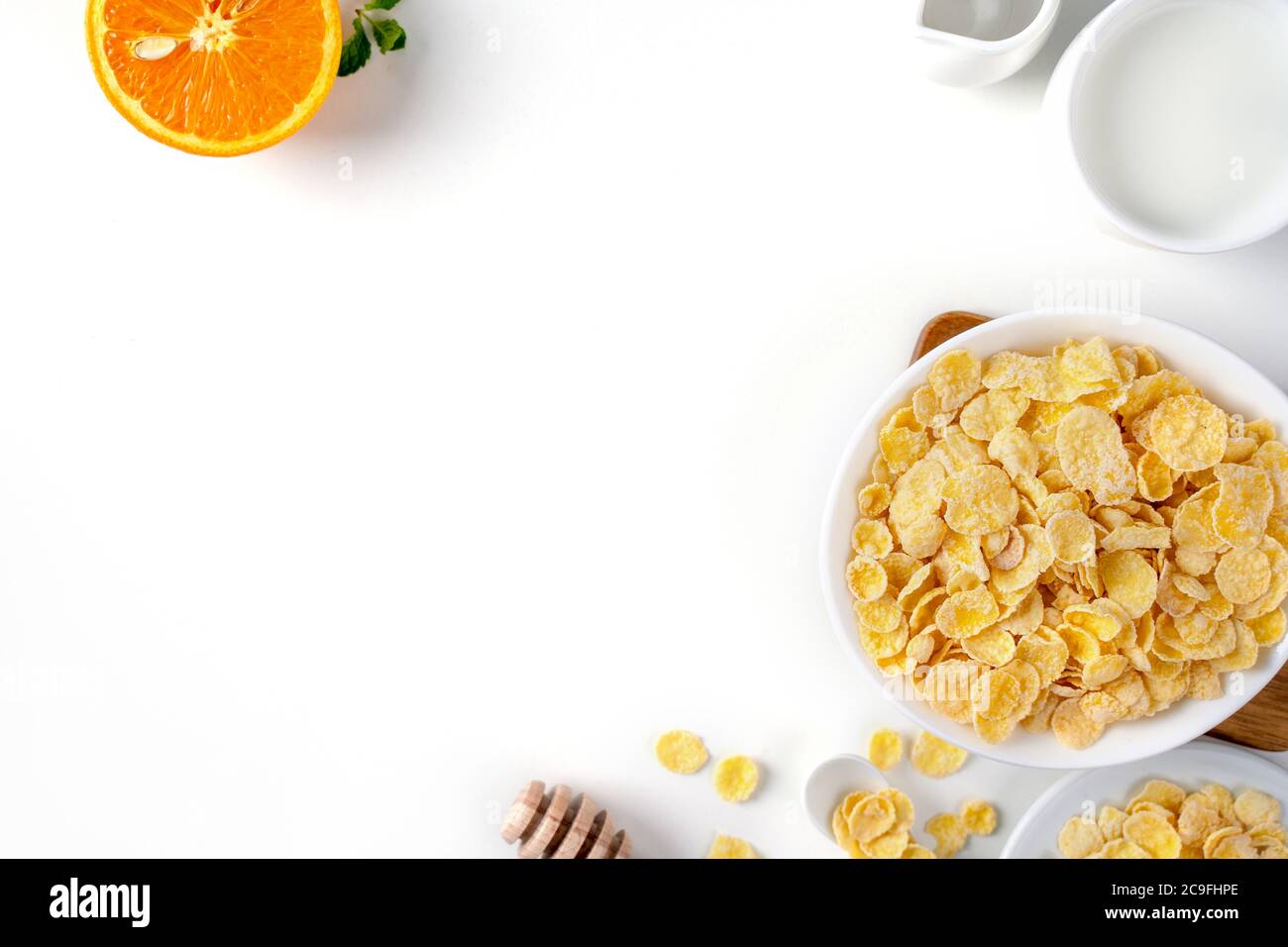 Corn flakes bowl sweeties with milk and orange on white background ...