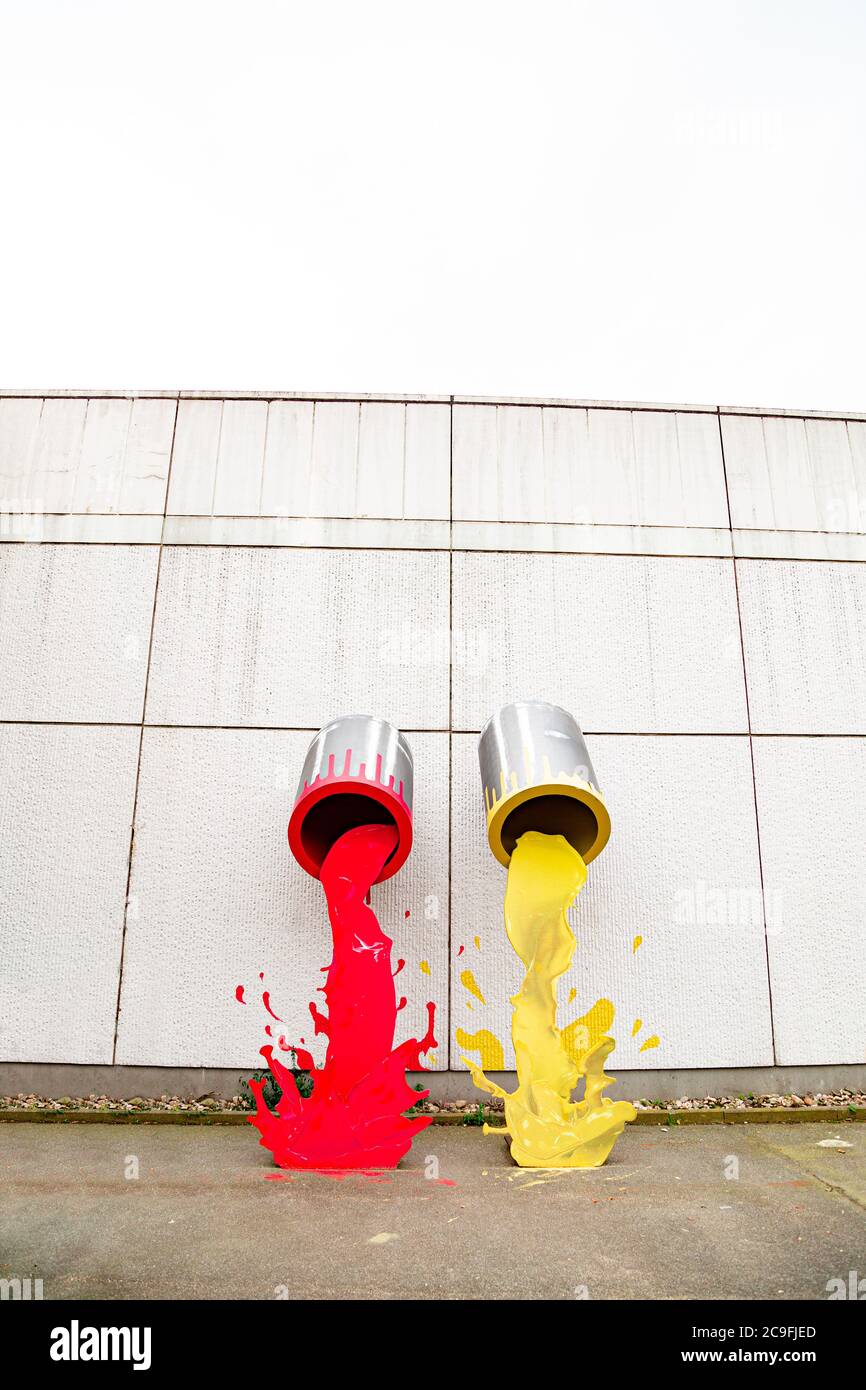 Two metal buckets pouring red and yellow paint Stock Photo - Alamy
