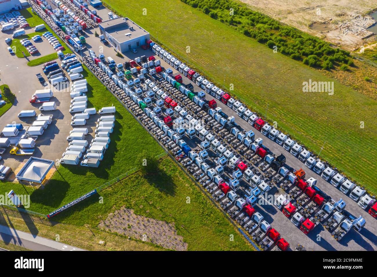 Lots of freight trailers. Cars are in several rows. Truck parking ...