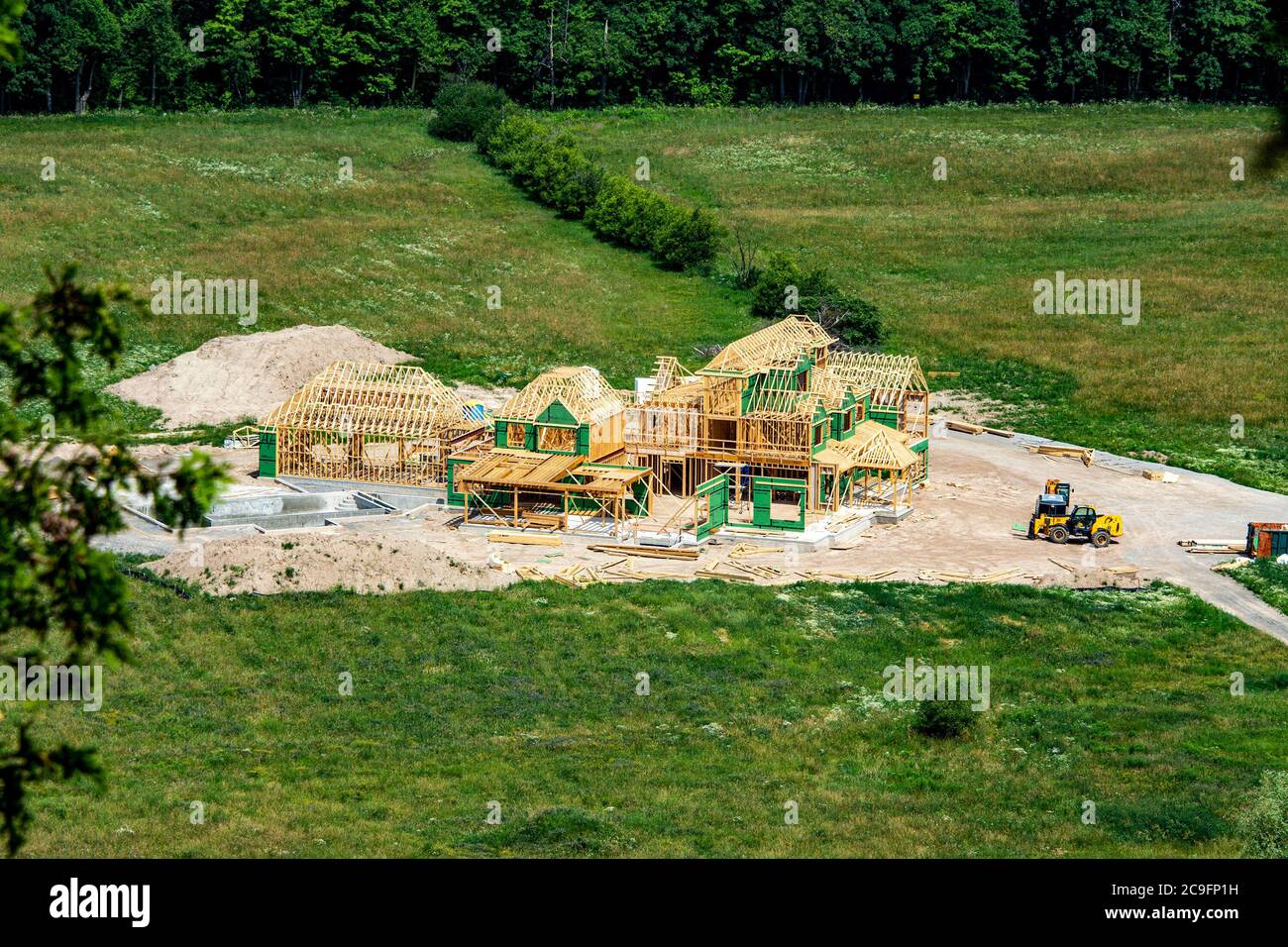 construction of a large wooden house on a green field Stock Photo - Alamy