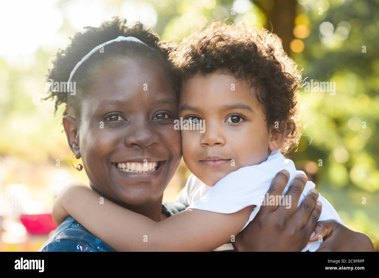 Portrait of an happy african mother and baby embracing and looking at ...