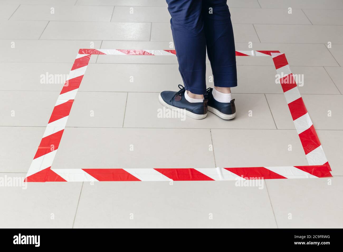 Person stand in line keeping social distance,standing behind warning ...