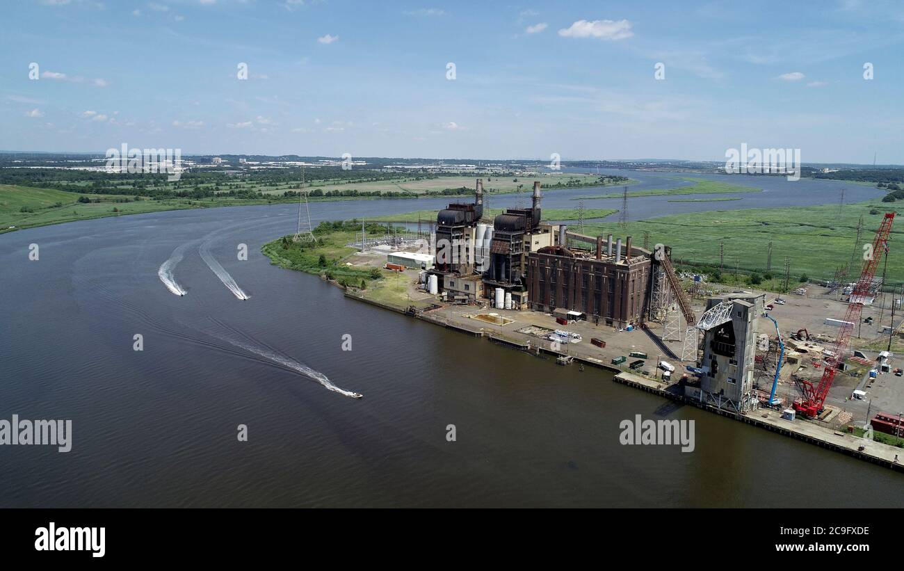 Aerial view of Jet skiers in front of old coal power plant being ...