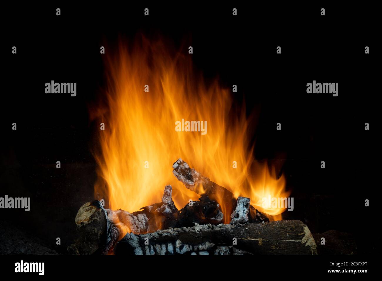 Flames in different forms of a bonfire made with orange tree trunks in ...