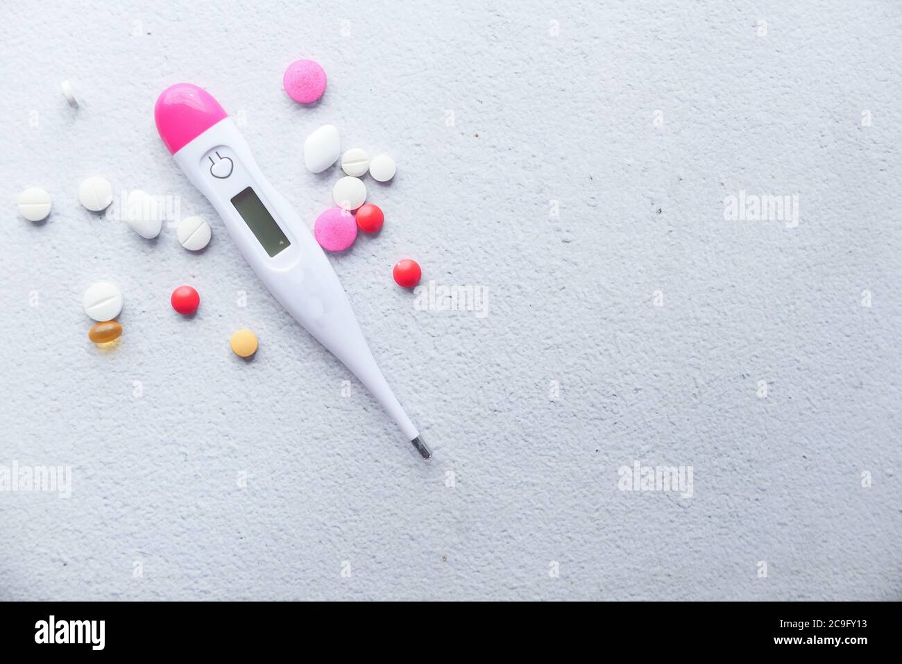 digital thermometer and pills on white texture background Stock Photo ...