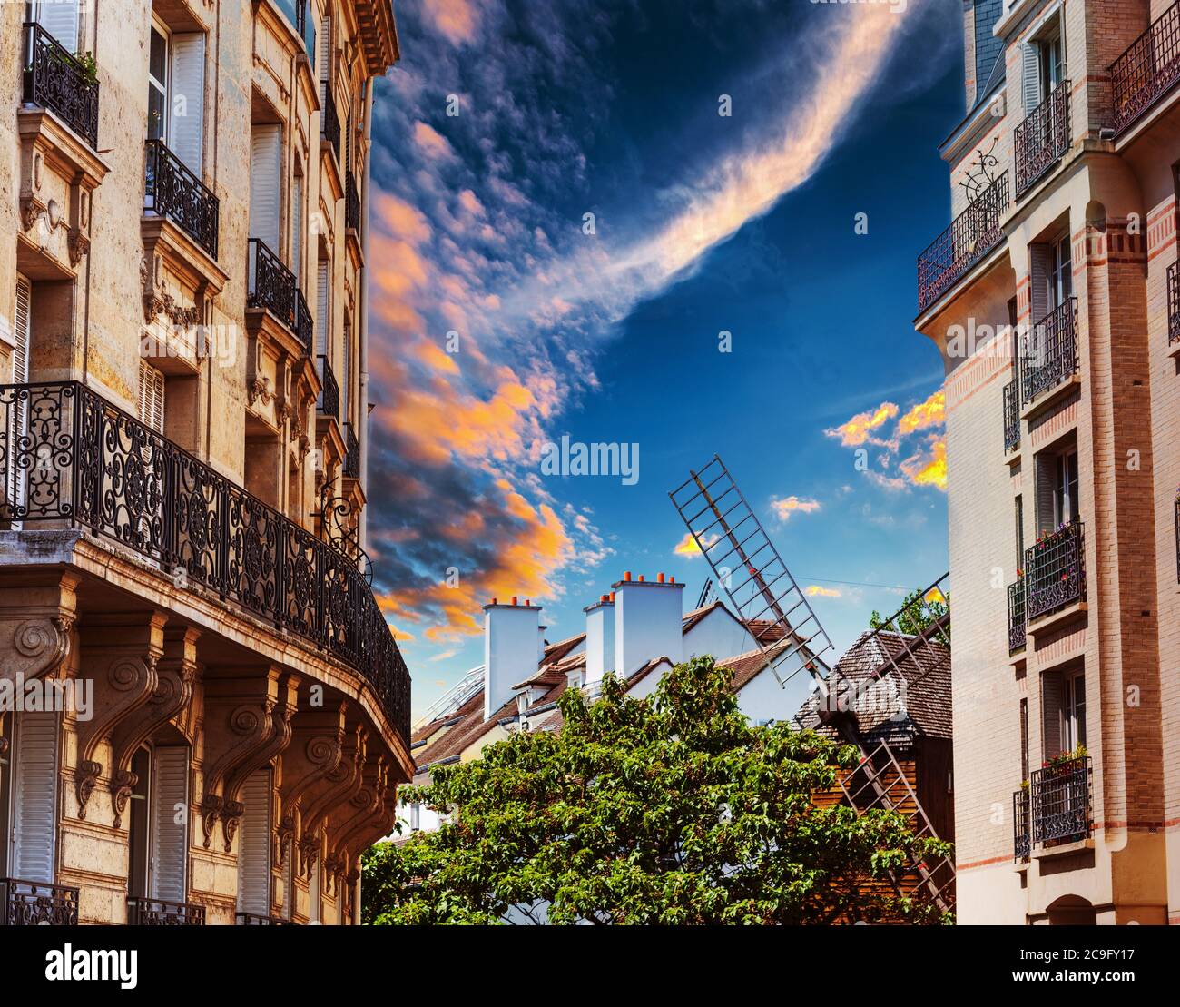 Elegant building and windmill in Montmartre neighborhood at sunset ...