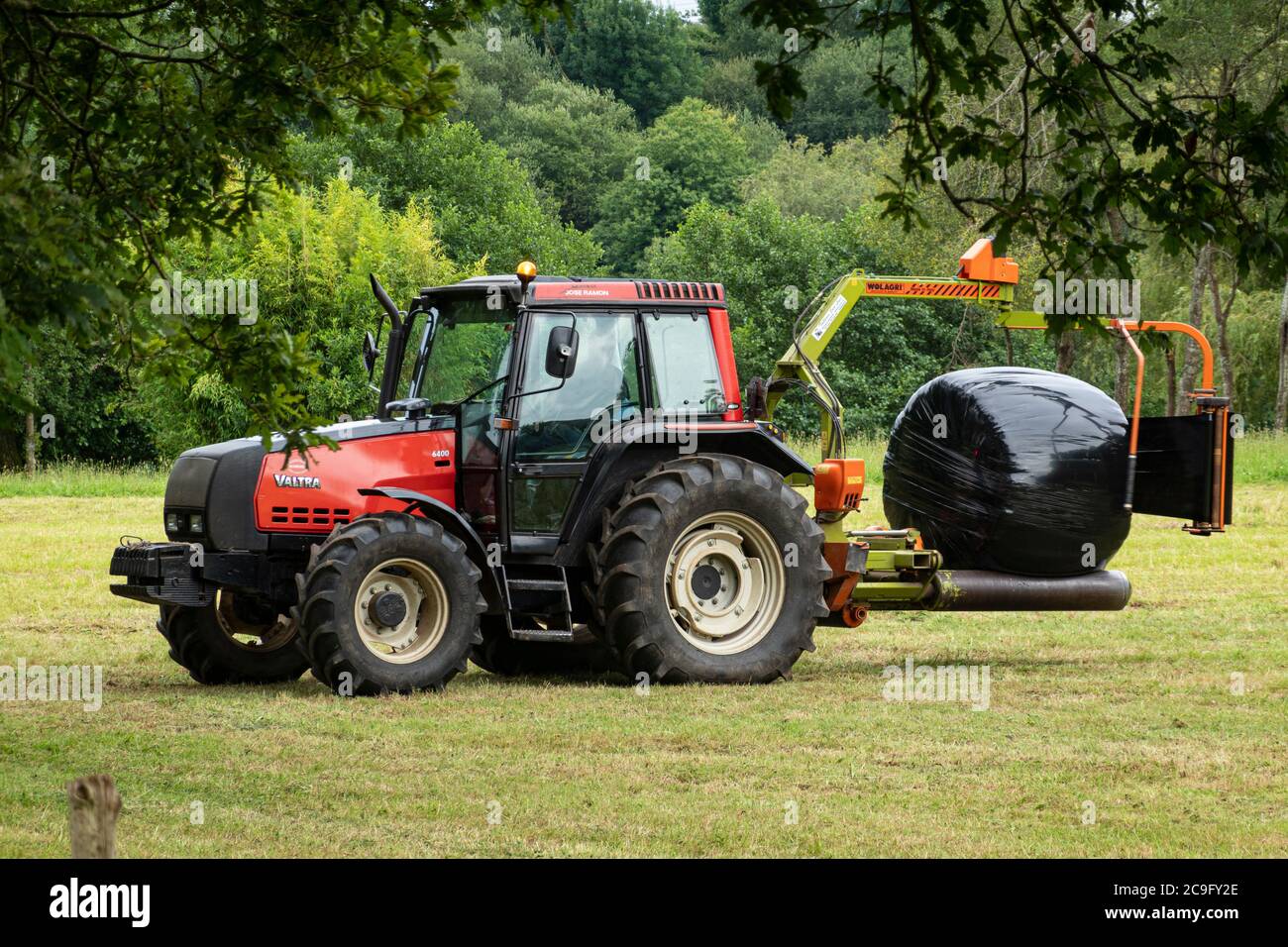 tractor wrapping grass in a ball Stock Photo - Alamy