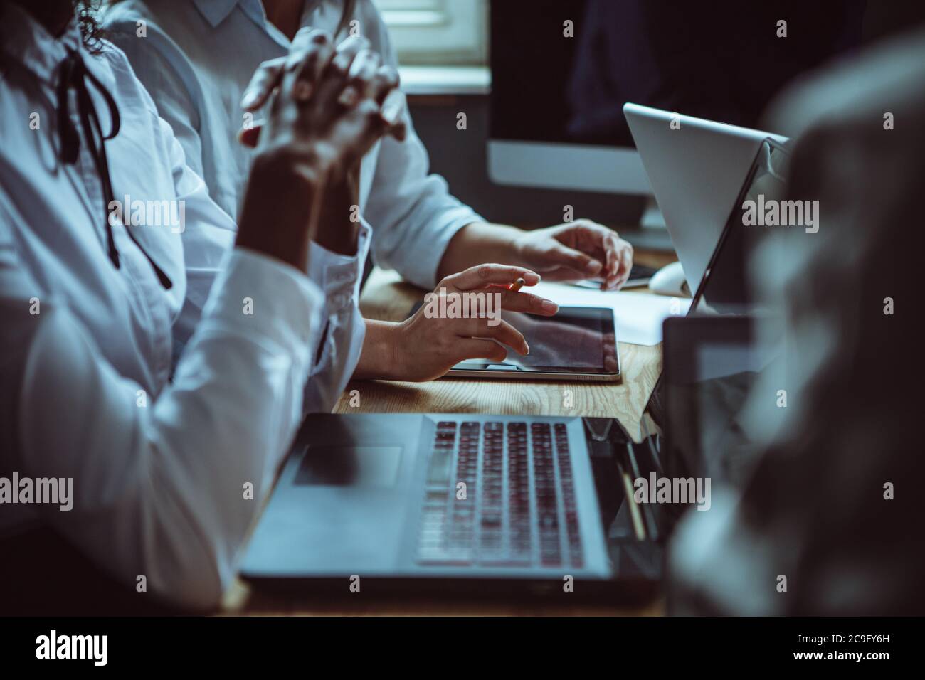 Diverse office staff using computers during business meeting. Human ...