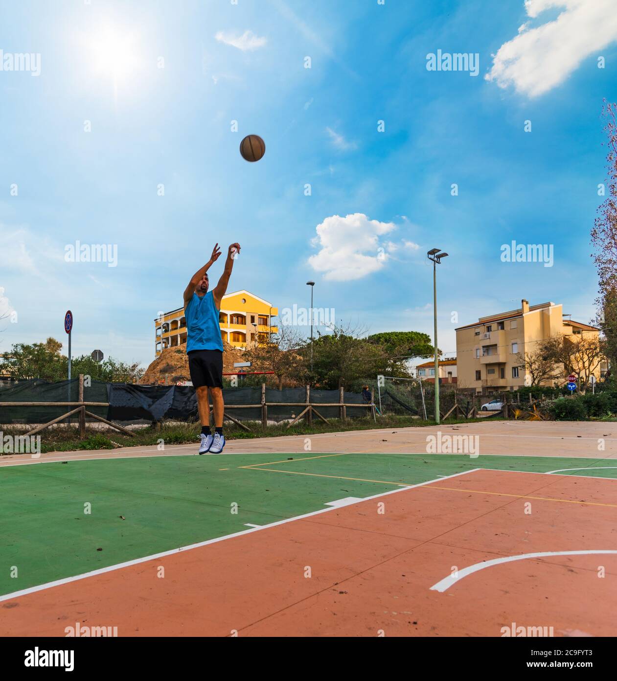 Basketball player practicing jump shot in an outdoor court Stock Photo ...