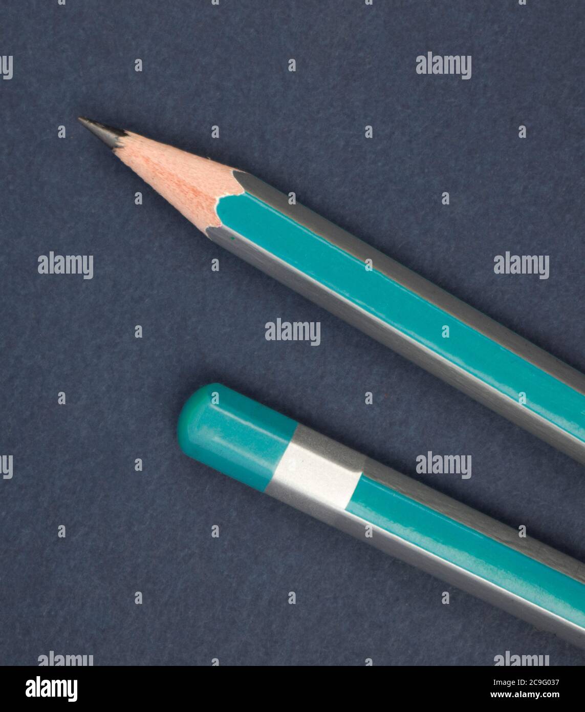 Two blue color wood pencil crayon placed on a deep blue color note ...