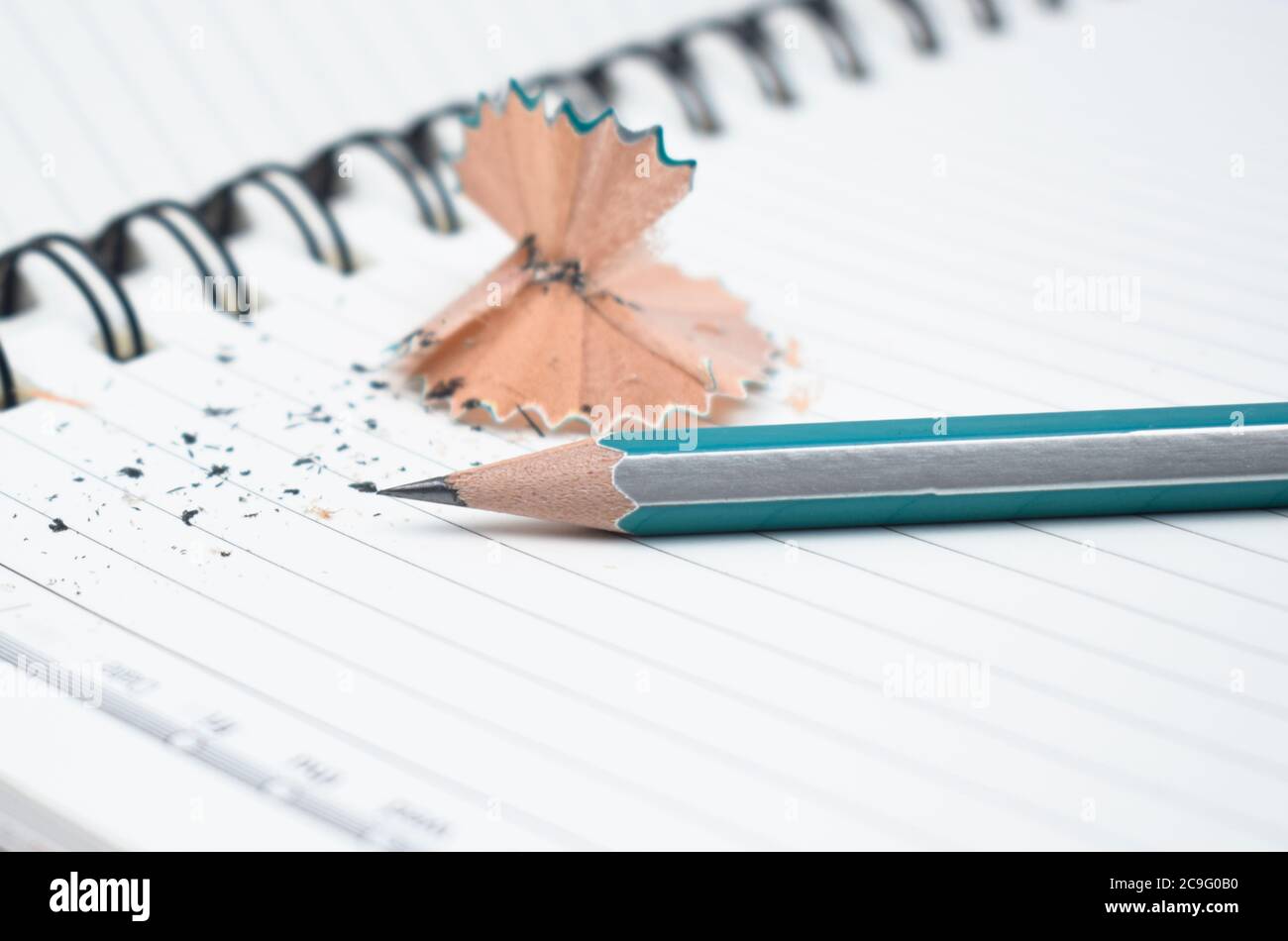 Light blue color wood pencil crayon placed in front of a white colored ...
