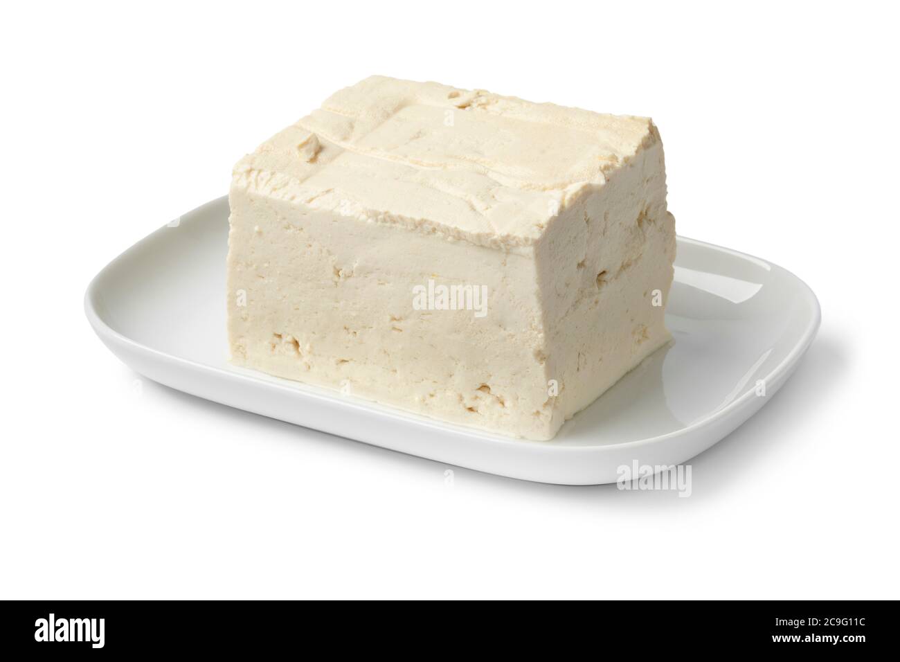 Piece of fresh white silk tofu in a white bowl close up isolated on ...
