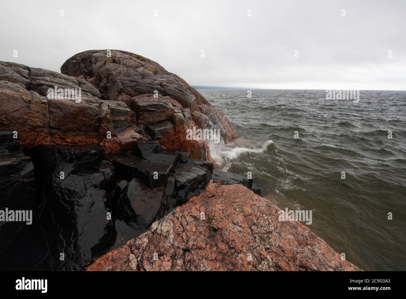 Surf pounds multi-coloured bedrock on Lake Superior's northern shore ...