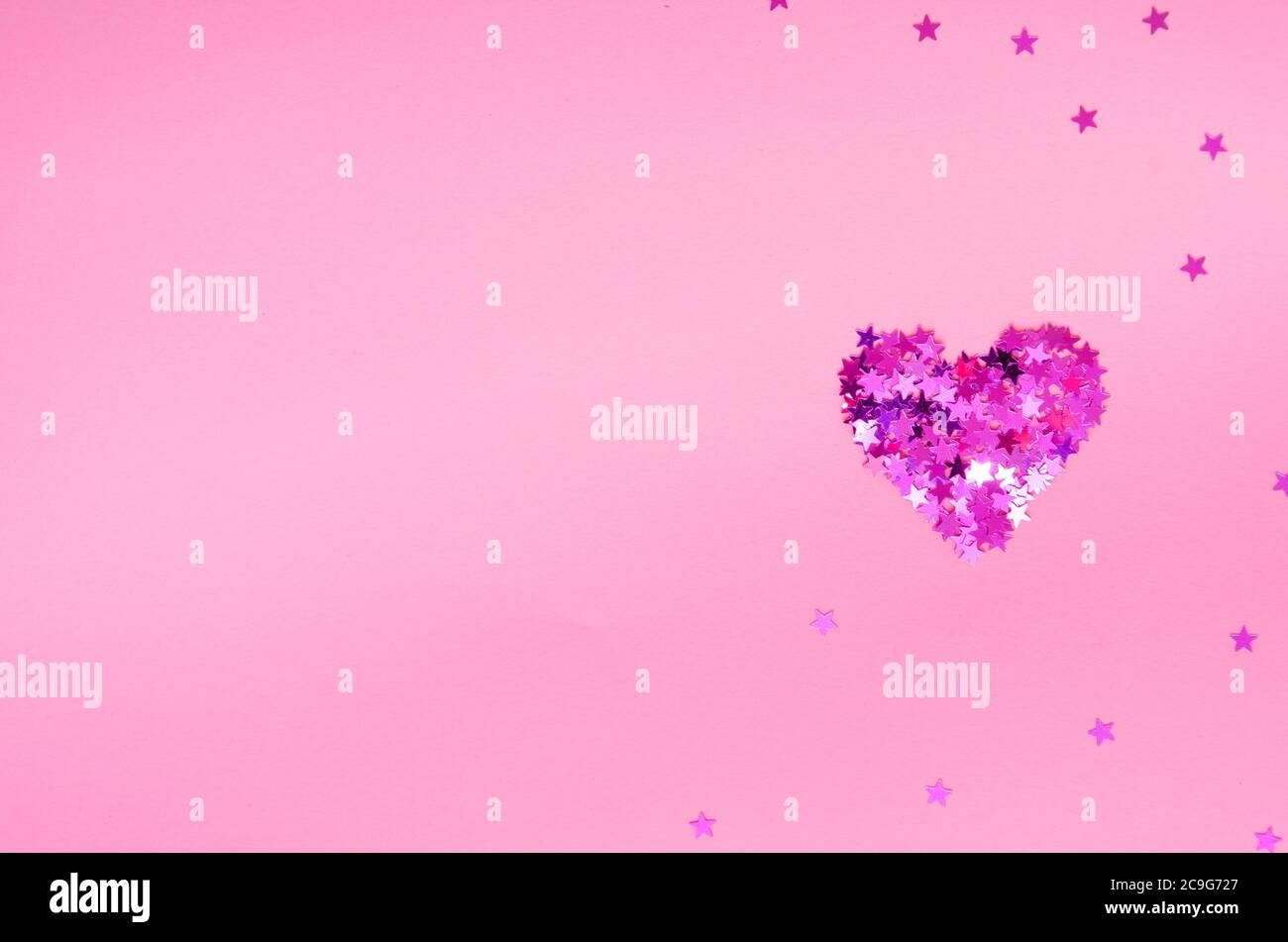 Pink glittering heart made of small stars on a light pink background ...