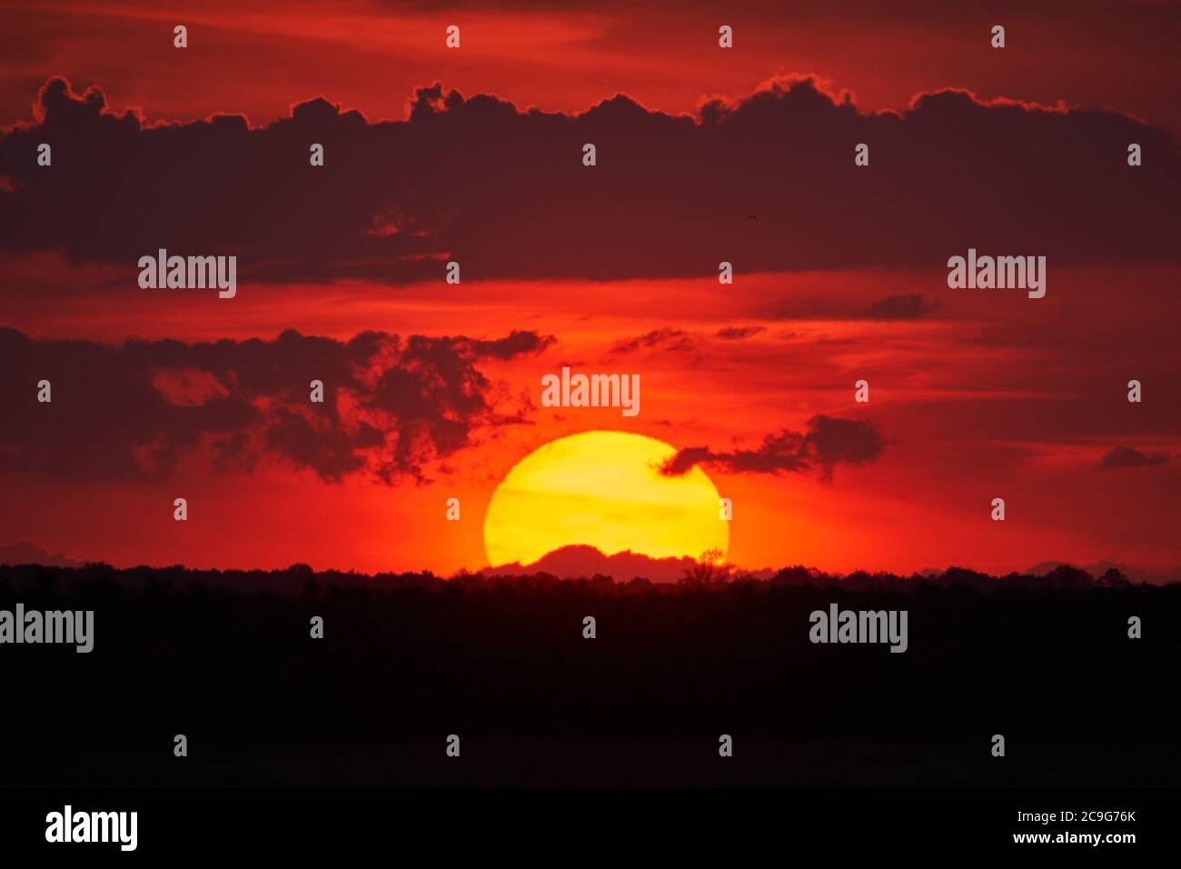 Big red sun setting through hi-res stock photography and images - Alamy