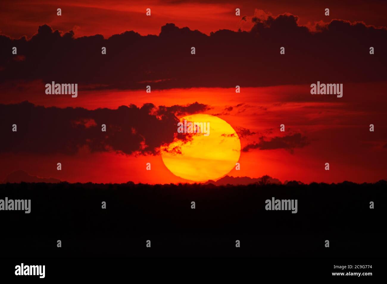 Big red sun setting through hi-res stock photography and images - Alamy
