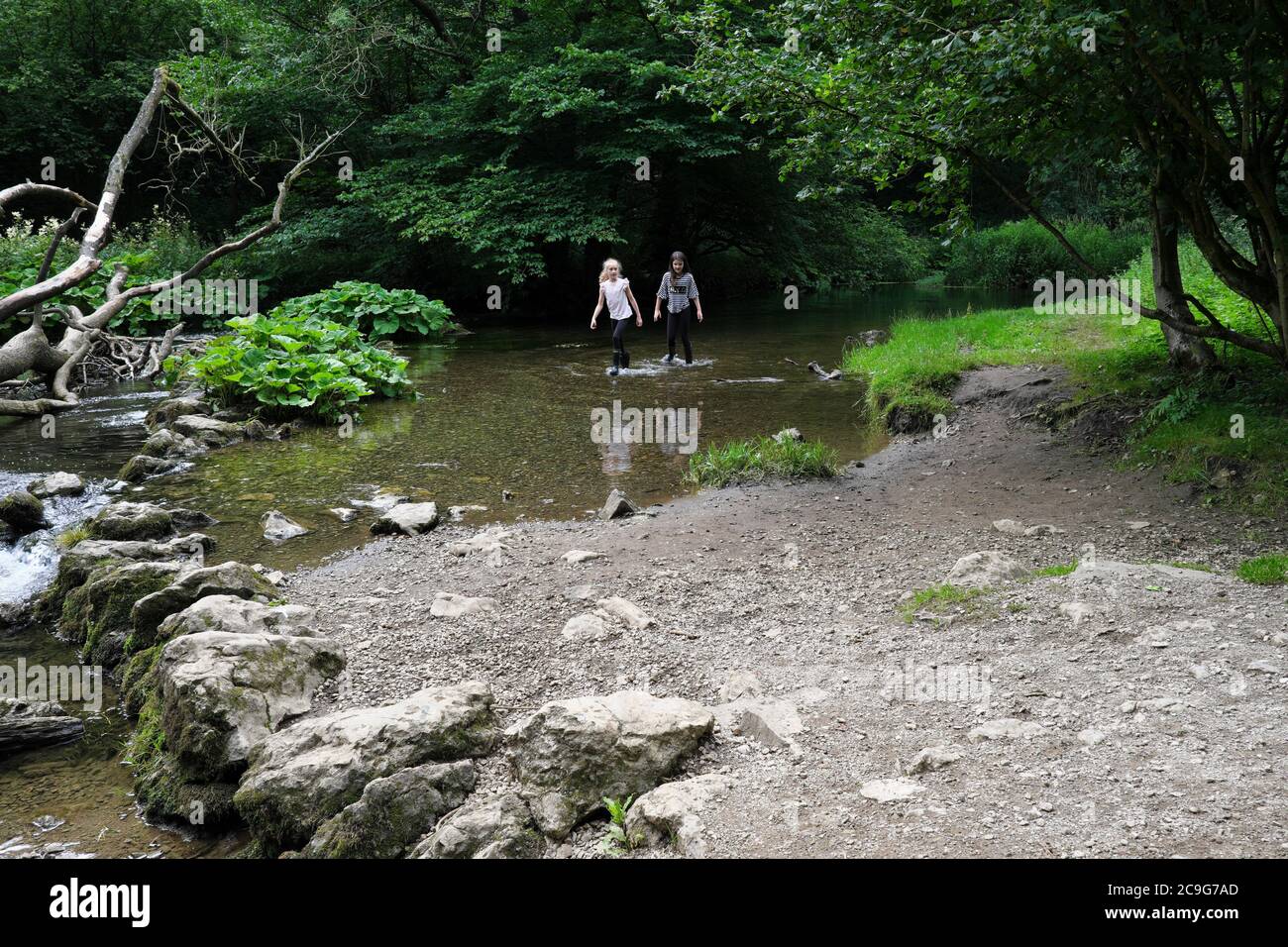 Two Young Girls Walking Down A Stream Near Milldale In The Peak ...
