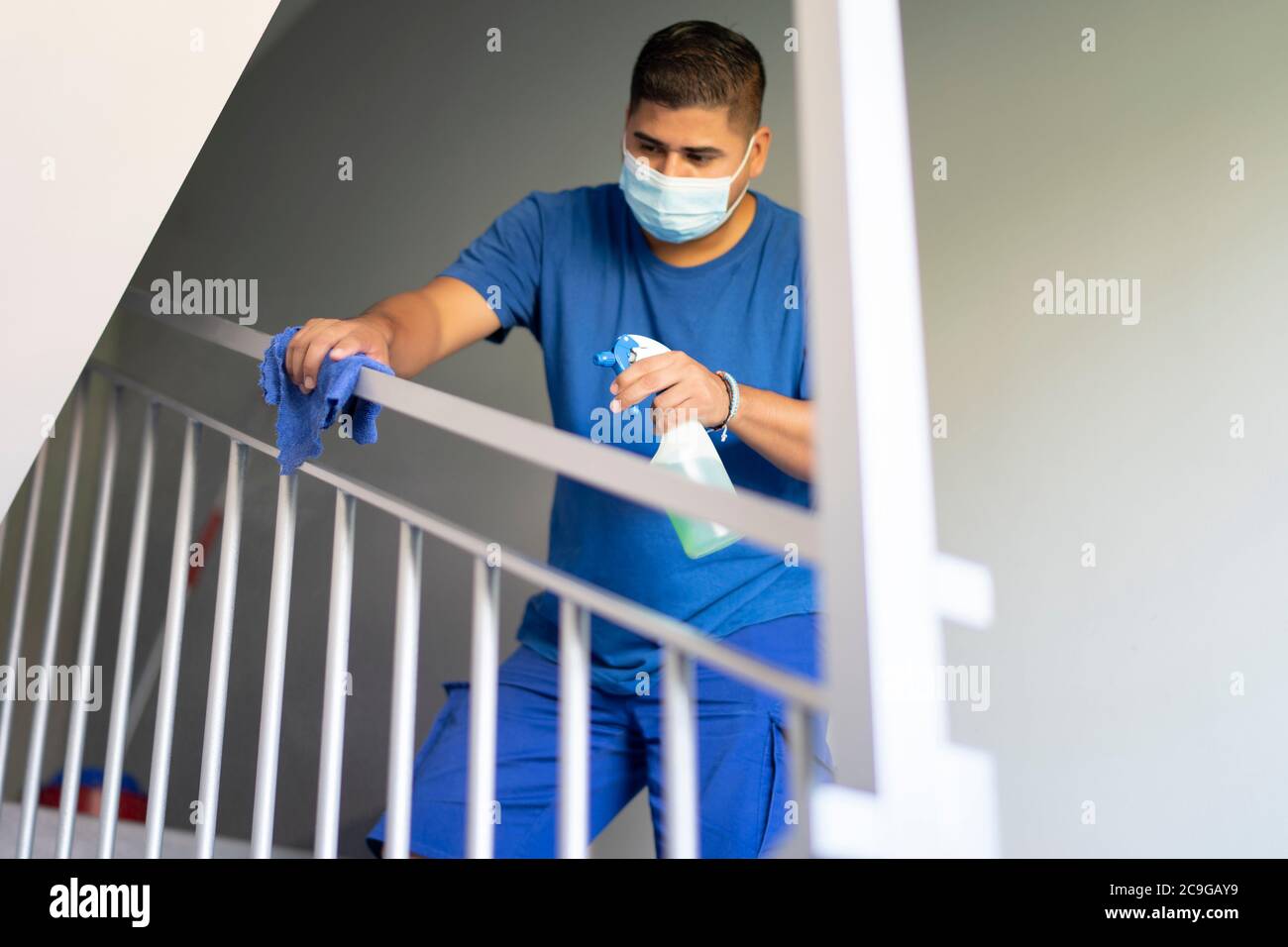 cleaning staff disinfecting the stair railing to avoid covid19 Stock ...