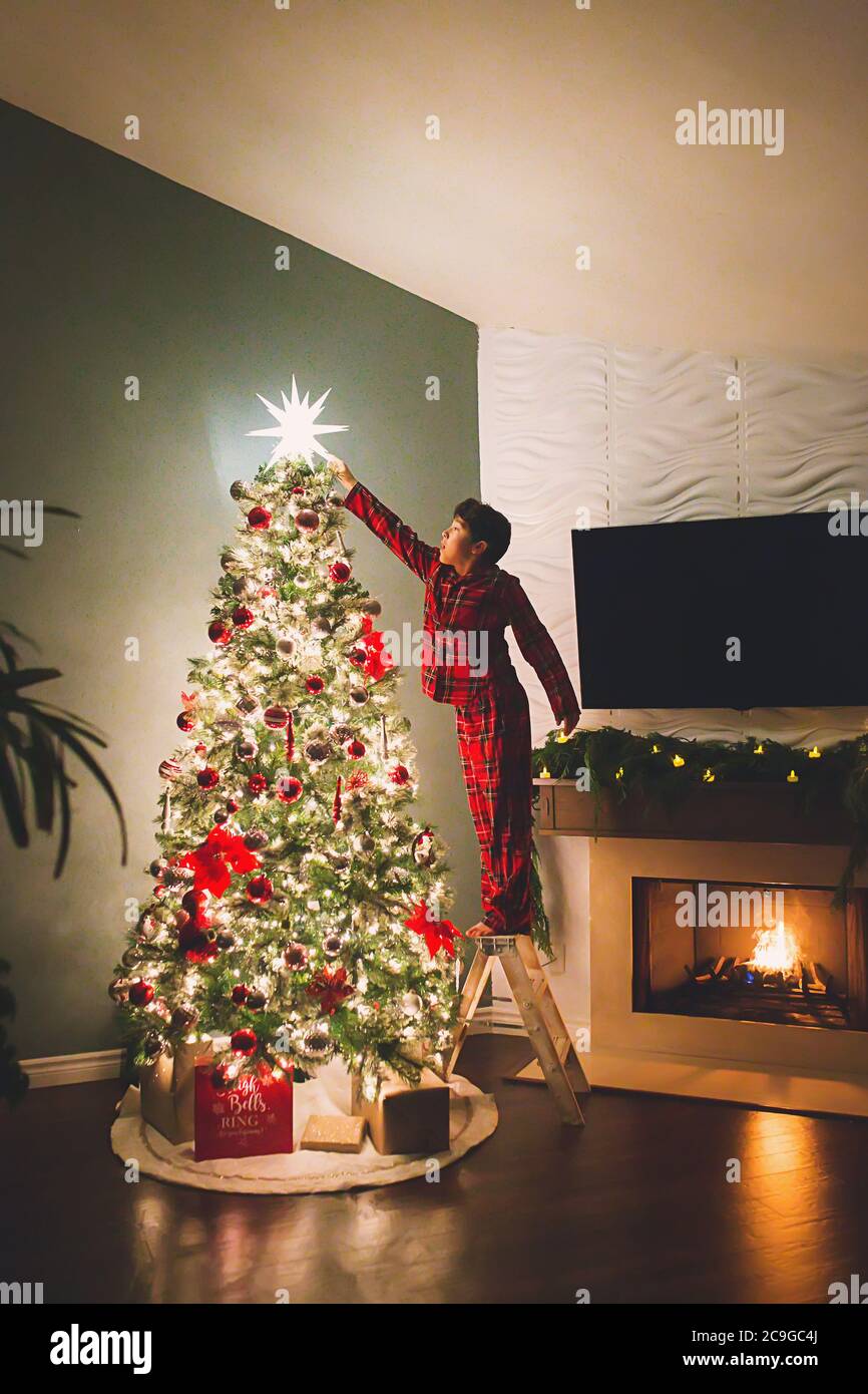 Boy Putting A Star On Top Of Christmas Tree At Home Stock Photo Alamy boy-putting-a-star-on-top-of-christmas-tree-at-home-stock-photo-alamy