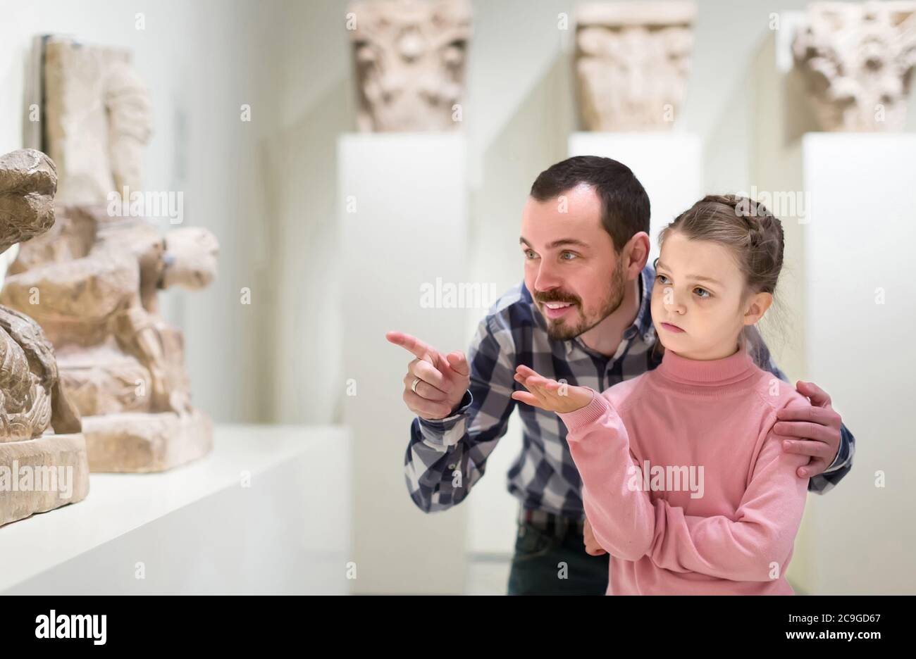 young european father and daughter looking at ancient bas-reliefs in ...