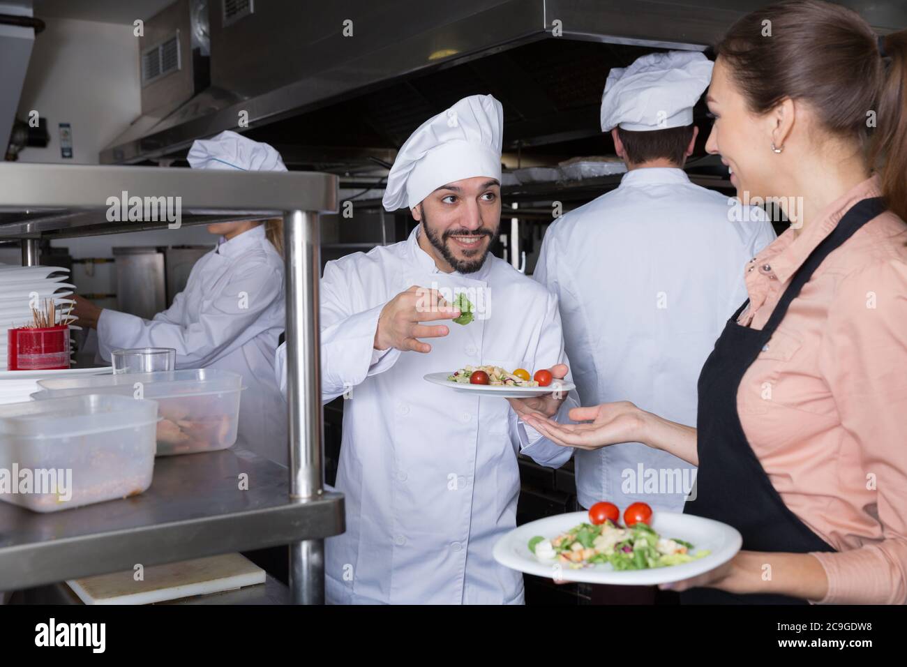 Staff of restaurant with head chef working together in kitchen Stock ...
