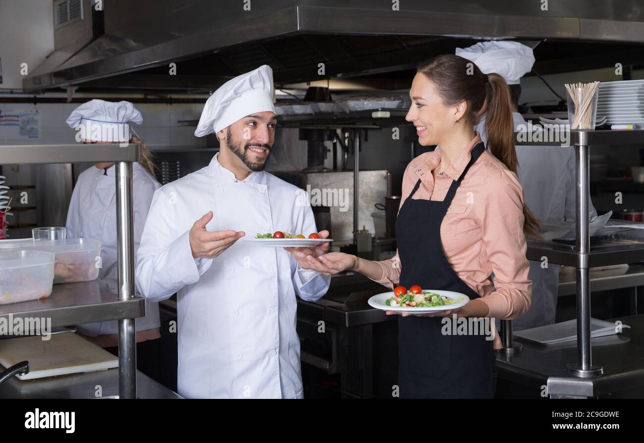 Head chef checking dishes in kitchen of restaurant before serving ...
