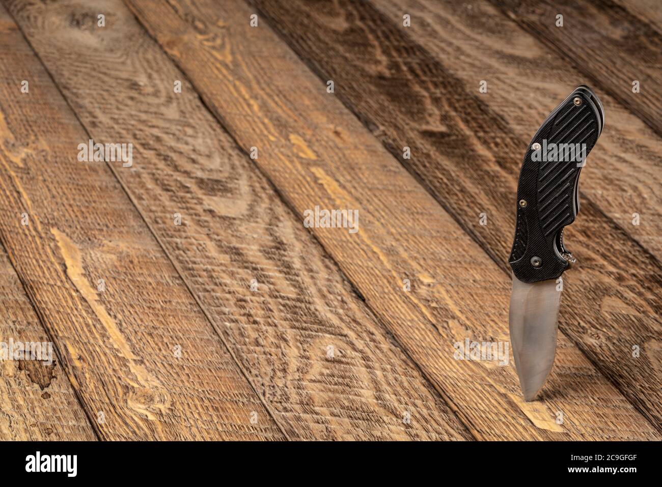 opened, used pocket knife with assisted opening on a rustic wooden deck ...
