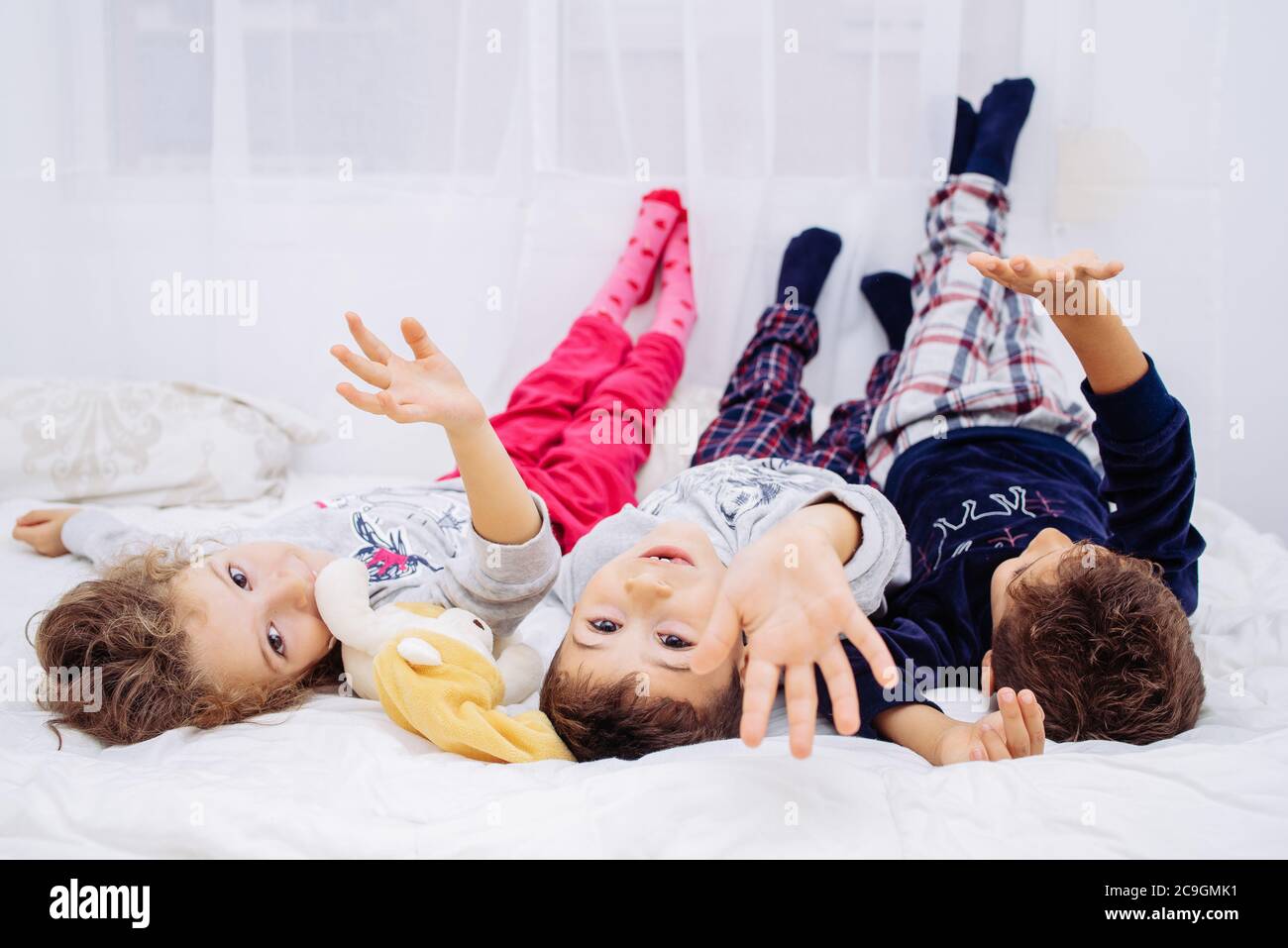 Three small children happily playing together in the apartment Stock ...
