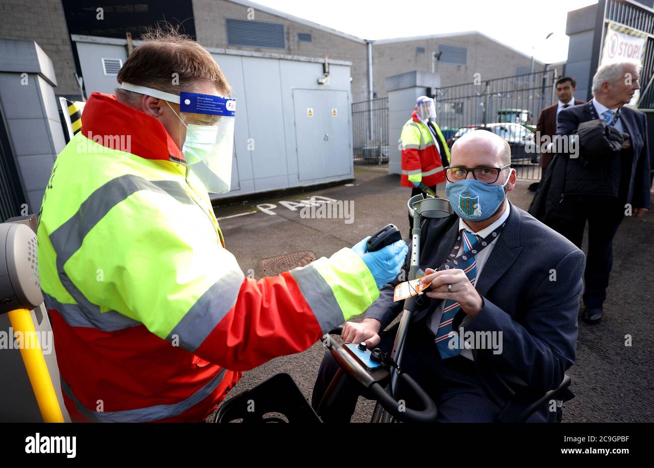 Fans have their tickets checked by security staff wearing PPE ahead of ...