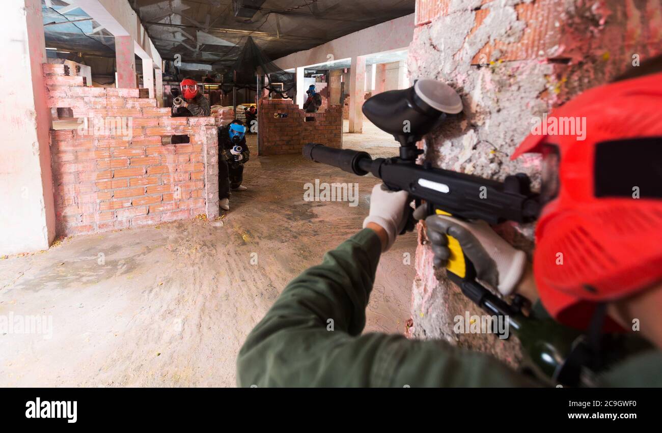 Portrait of player who is targeting in opponents on paintball field ...
