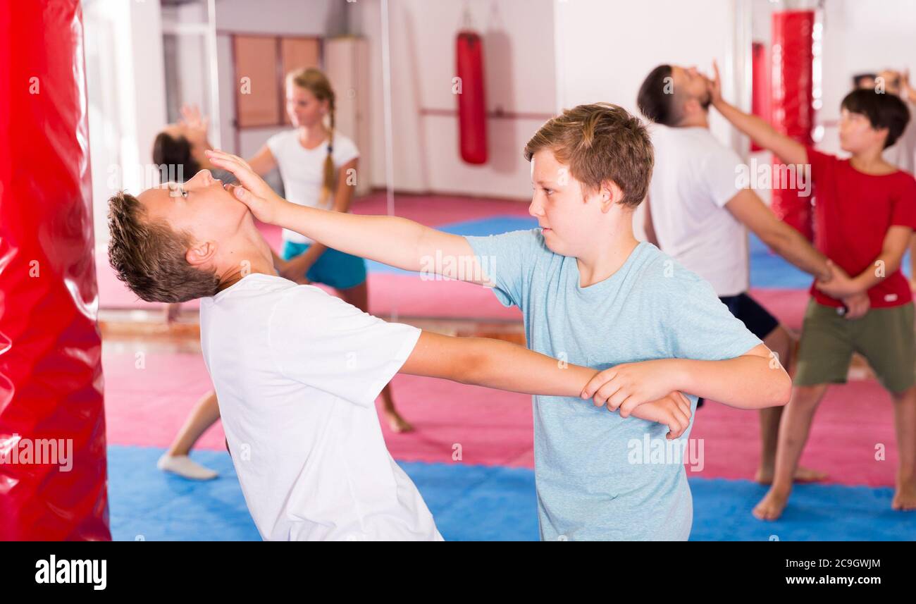 Kids with adults practicing effective techniques of self-defence in ...