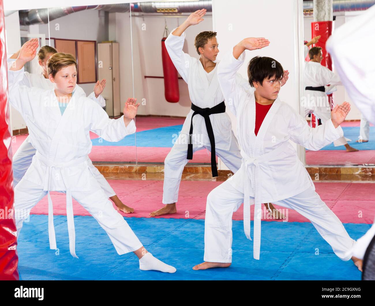 Kids in kimonos practicing effective karate techniques in group workout ...