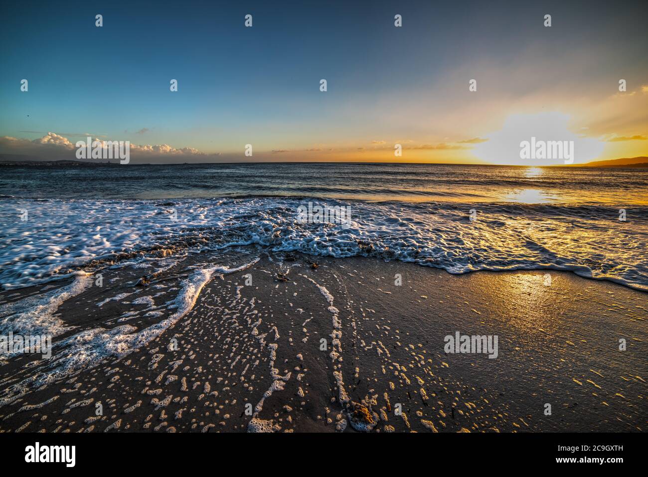 Sandy shore under a clear sky at sunset. Sardinia, Italy Stock Photo ...