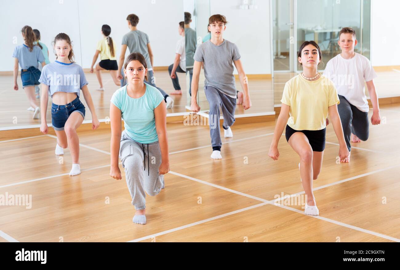 Positive teenage dancers doing dance workout during group class Stock ...