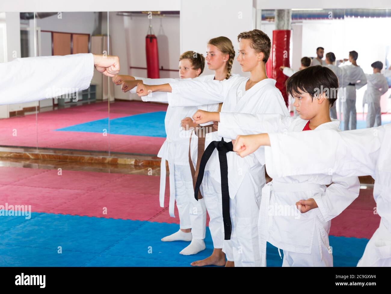 Kids in kimonos practicing effective karate techniques in group workout ...