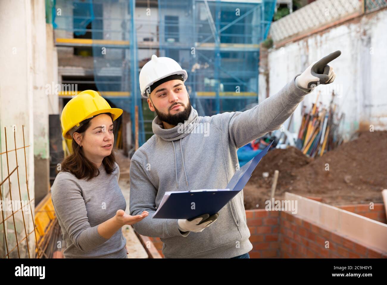Civil engineers inspecting process of building overhaul, comparing to ...