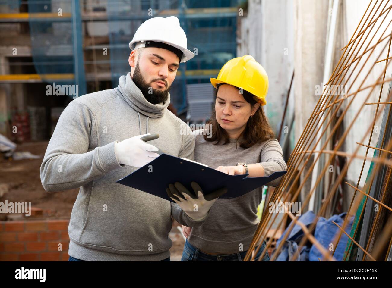 Civil engineers inspecting process of building overhaul, comparing to ...
