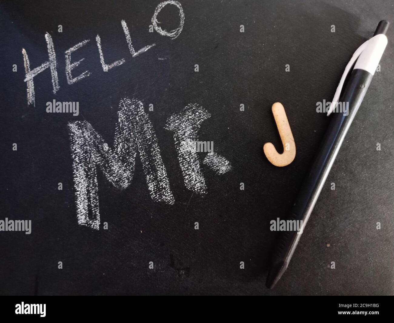 Hello mister J text displayed on chalk board concept with wooden ...