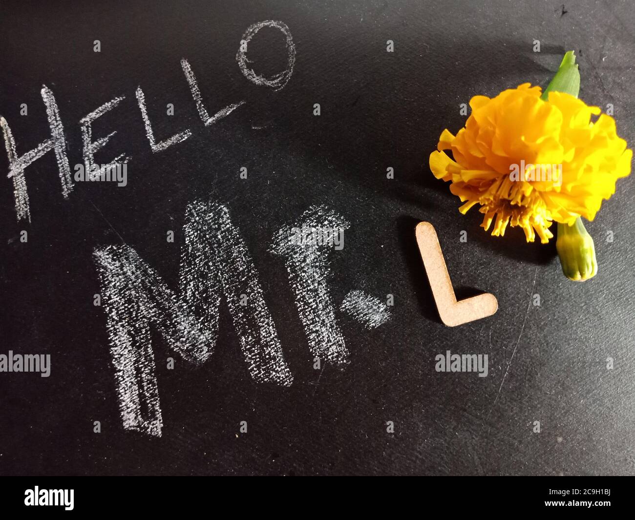 Hello mister L text displayed on chalk board concept with wooden ...