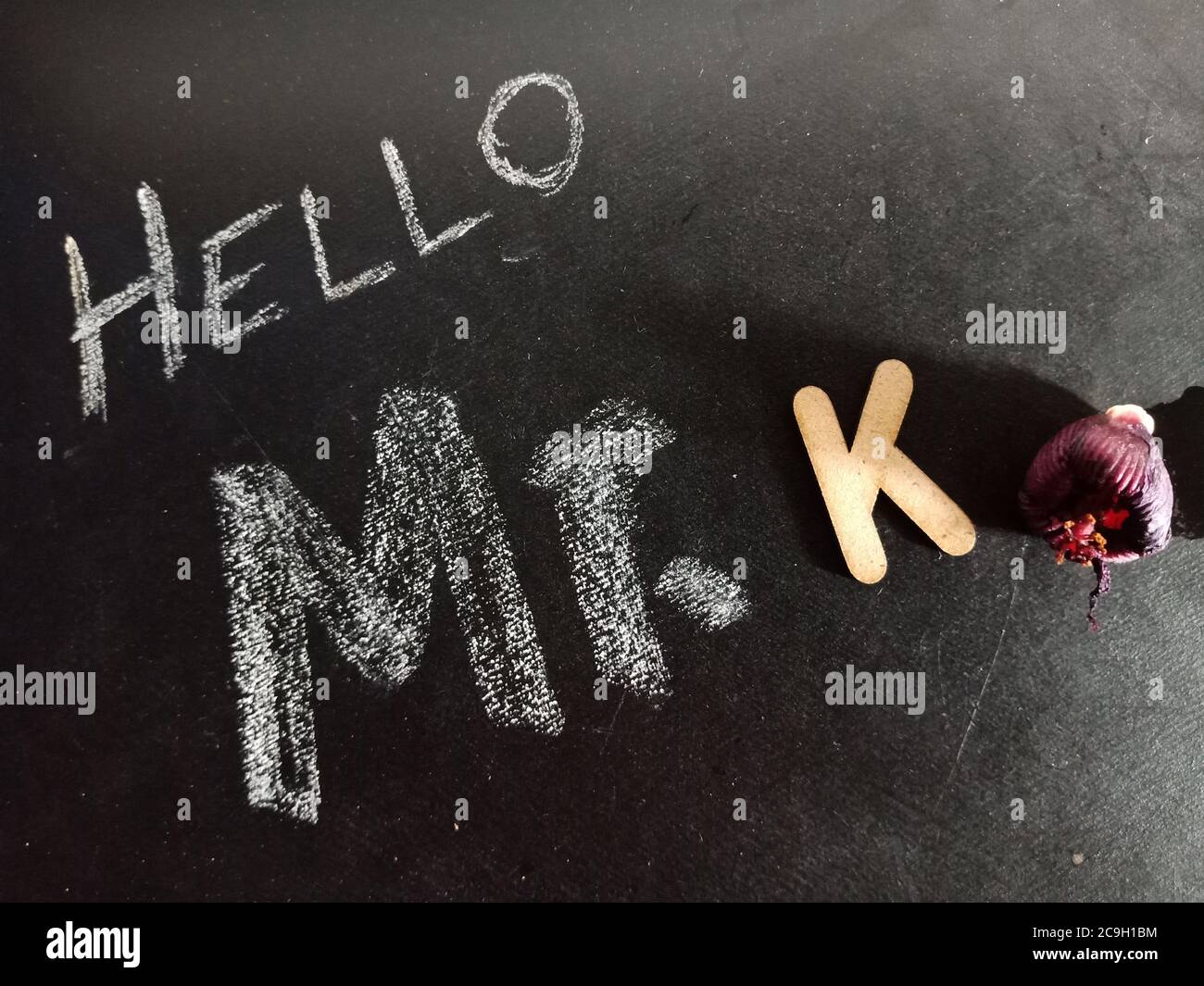 Hello mister K text displayed on chalk board concept with wooden ...