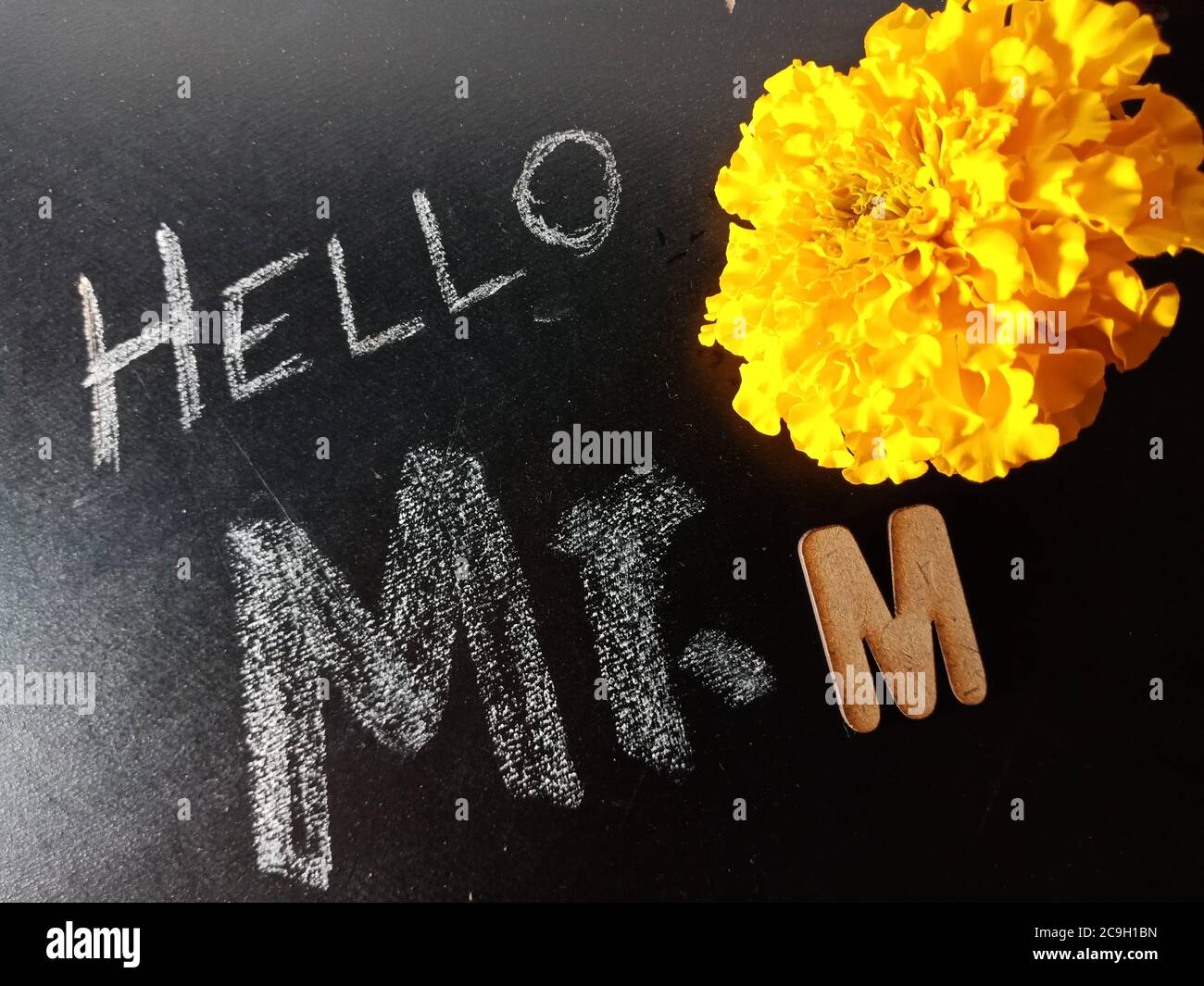 Hello mister M text displayed on chalk board concept with wooden ...