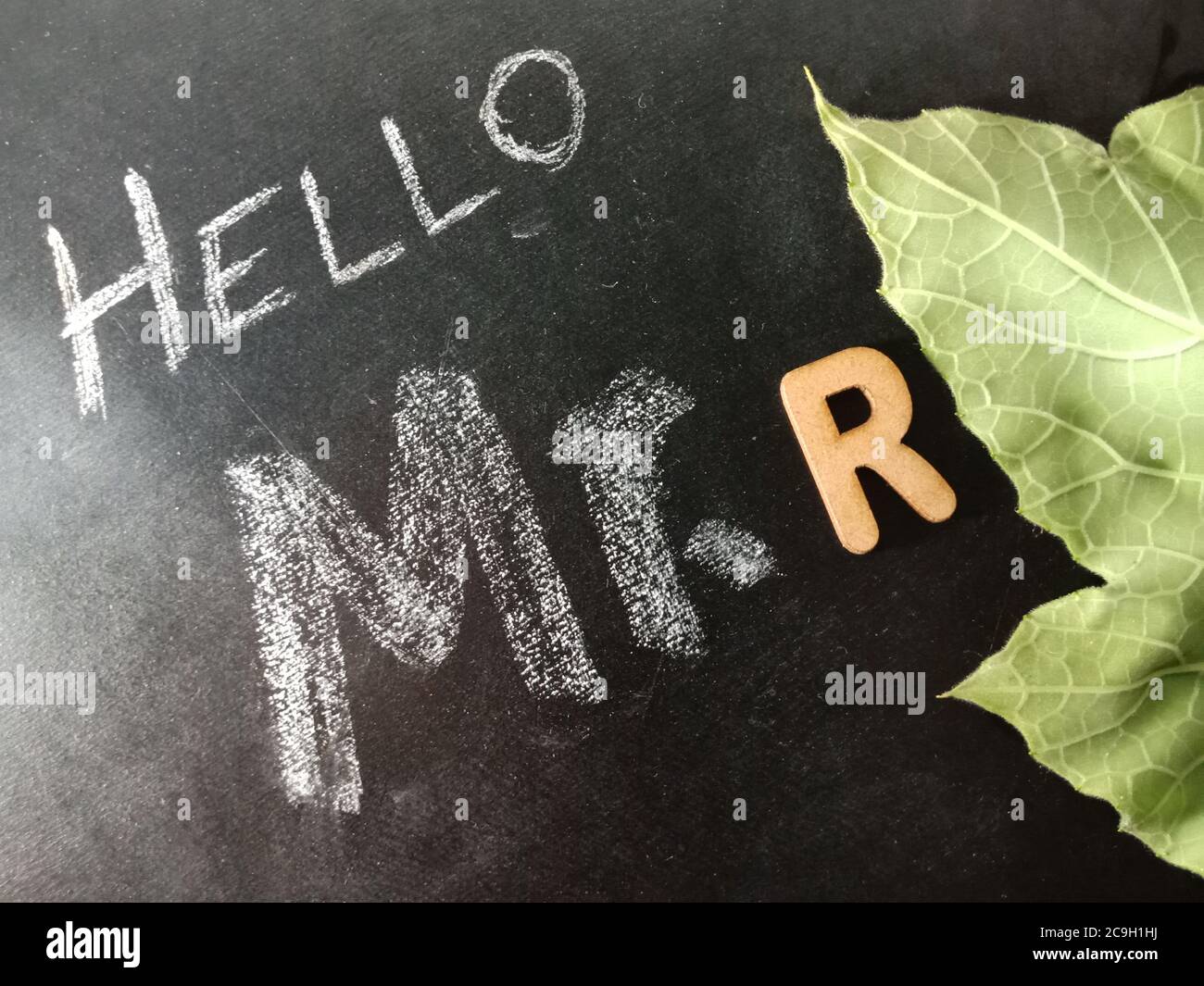 Hello mister R text displayed on chalk board concept with wooden ...