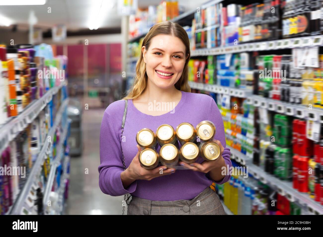 Active female customer selecting beer in supermarket Stock Photo - Alamy
