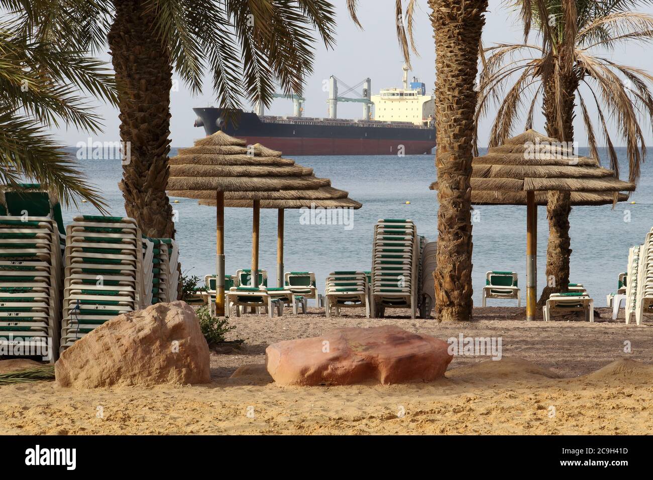 Morning on Eilat public beach. Large cargo Ship on horizon Stock Photo ...