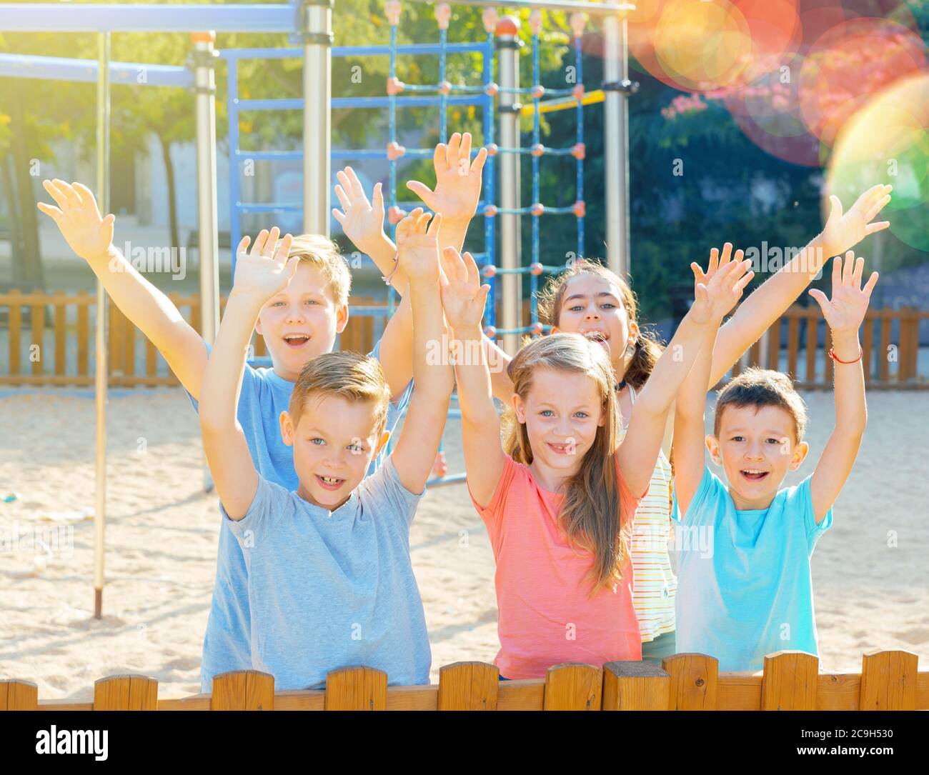 Cheerful kids posing at the playground together and hands up Stock ...