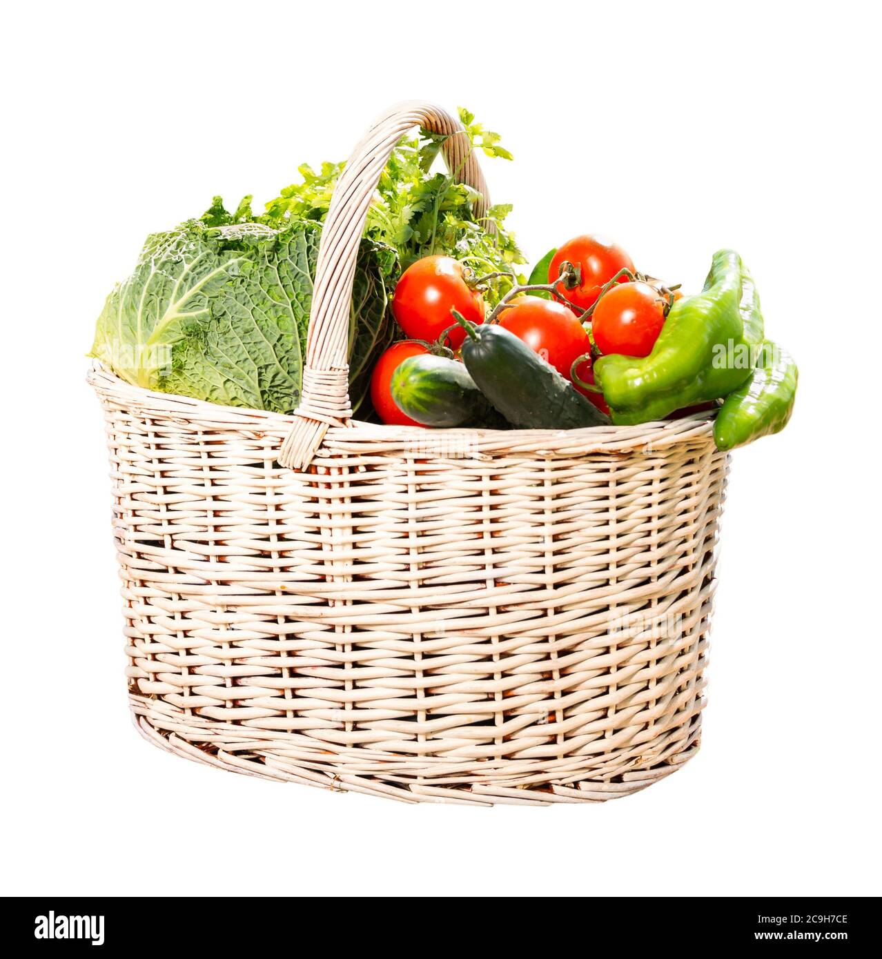 Basket with a crop of vegetables on a farm field. Isolated over white ...