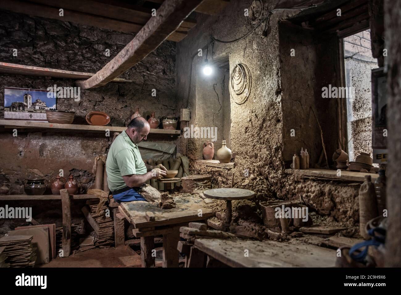 Male potter makes a pot on the pottery wheel. Terracotta pottery guy on ...