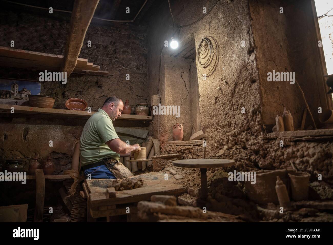 Male potter makes a pot on the pottery wheel. Terracotta pottery guy on ...