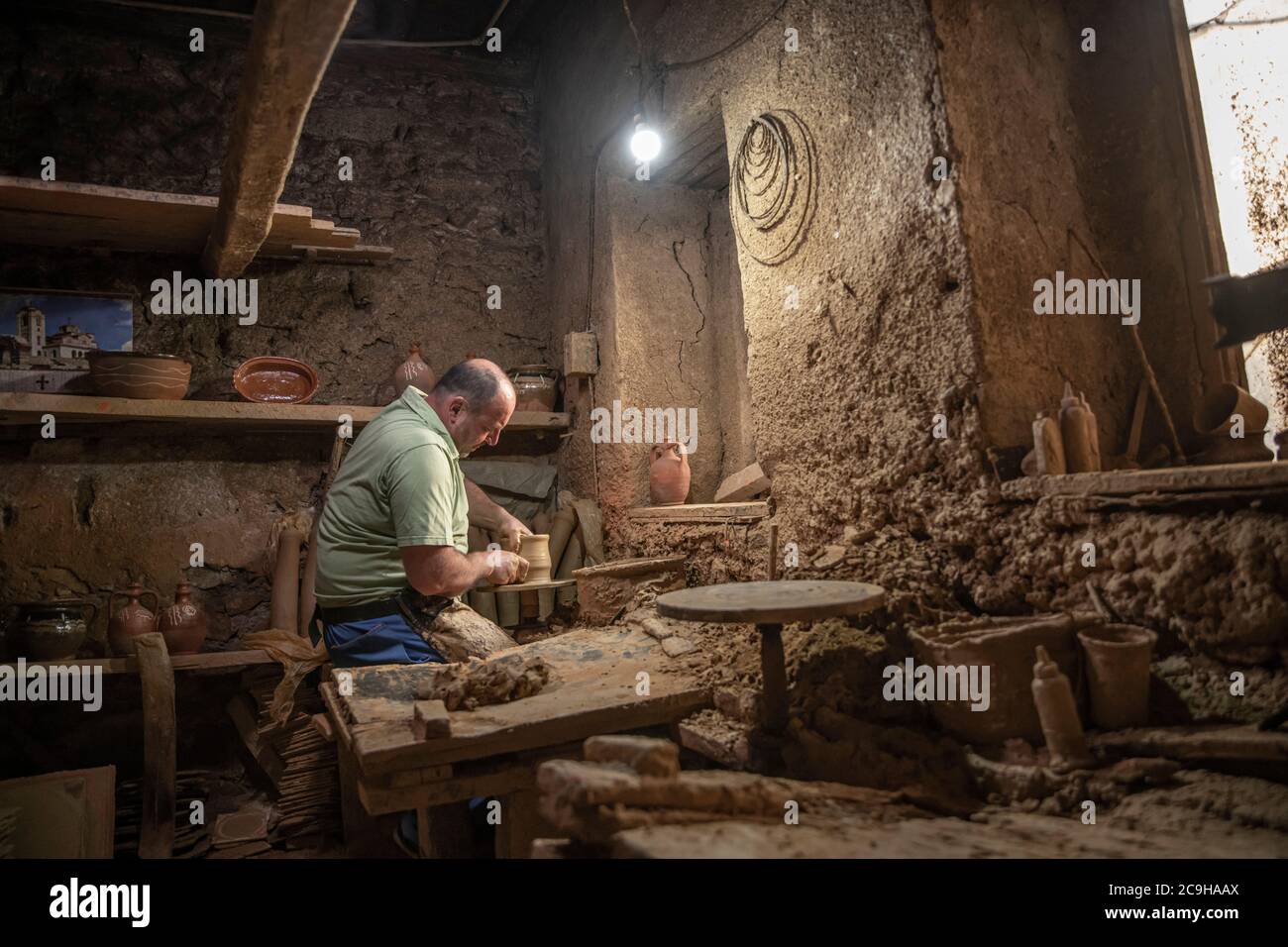 Male potter makes a pot on the pottery wheel. Terracotta pottery guy on ...